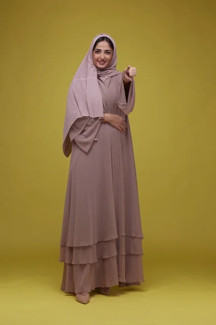 Saudi Woman in Abaya Pointing on Yellow Background - Photo