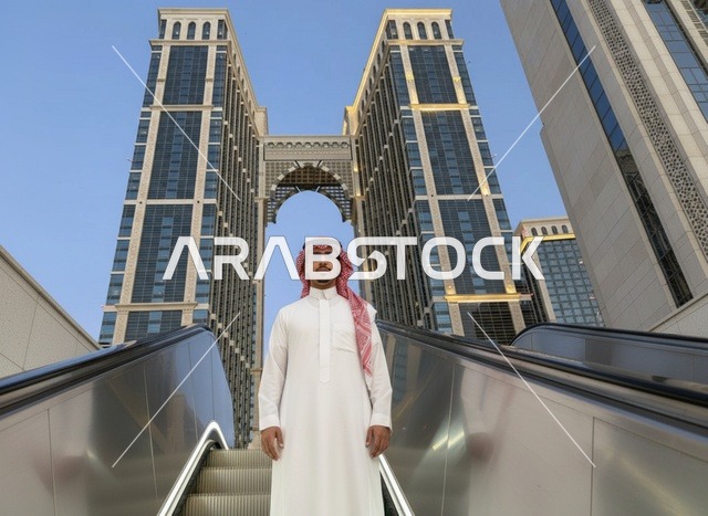 Saudi Man in Traditional Dress by Modern Skyscraper - Photo