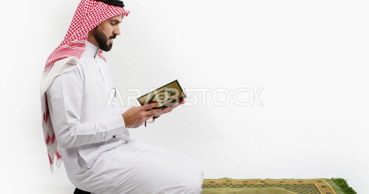 Portrait of a Saudi Muslim man, prays and reads the Quran on the prayer ...