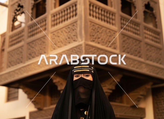 Saudi Woman in Traditional Abaya by Ancient Mashrabiya - Photo