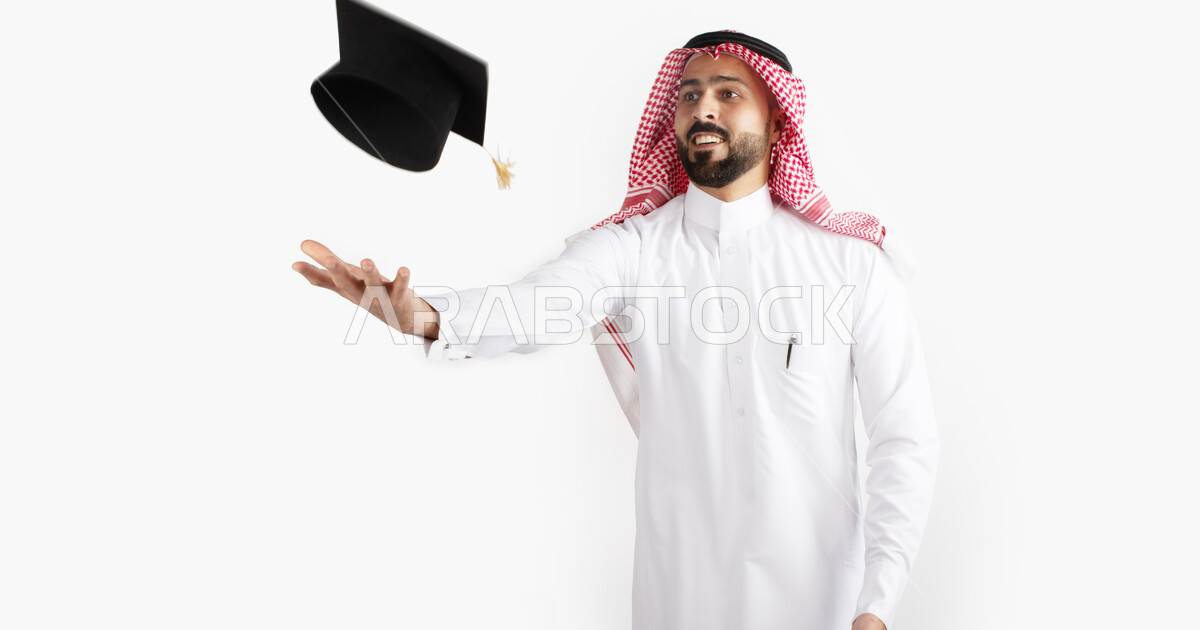 Portrait of a young happy Saudi Arabian graduate throwing a graduation ...