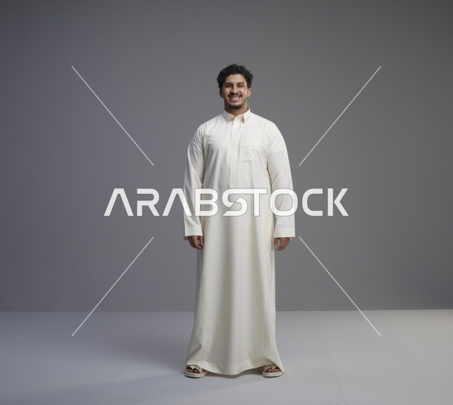 Saudi Man in Traditional Thobe on Grey Background - Photo