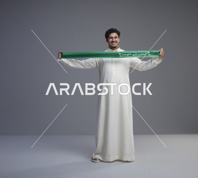 Saudi Man in White Thobe Holding Green National Scarf - Photo