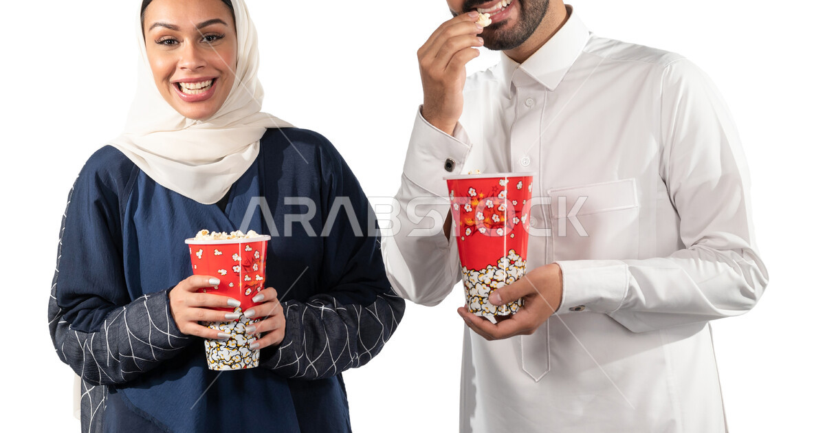 Portrait of a Saudi Arabian Gulf woman enjoying eating popcorn with her ...