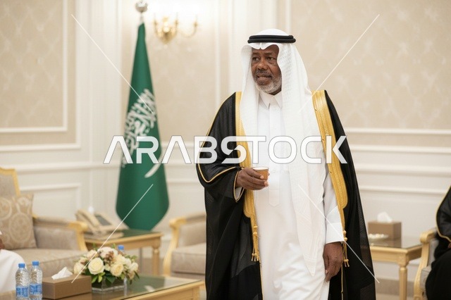 Saudi Man in Traditional Formal Bisht with National Flag - Photo