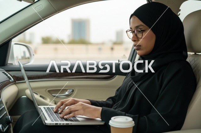 African Woman in Abaya Using Laptop Inside a Car - Photo