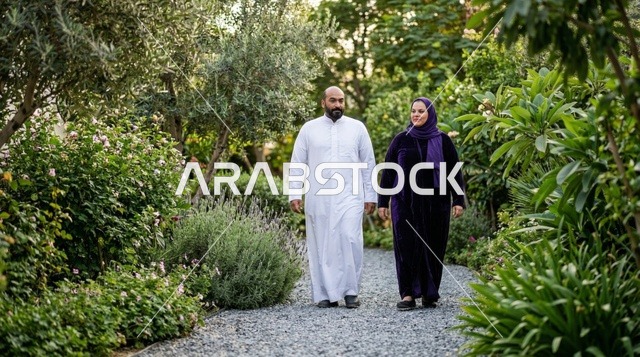 Saudi Couple Walking in Green Garden Traditional Dress - Photo