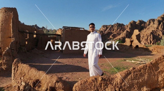 Saudi Man in Thobe at Ancient Mud Village Ruins - Photo