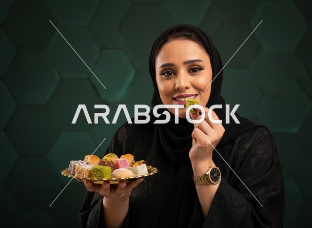 Saudi Woman in Abaya Holding Arabic Sweets Plate - Photo