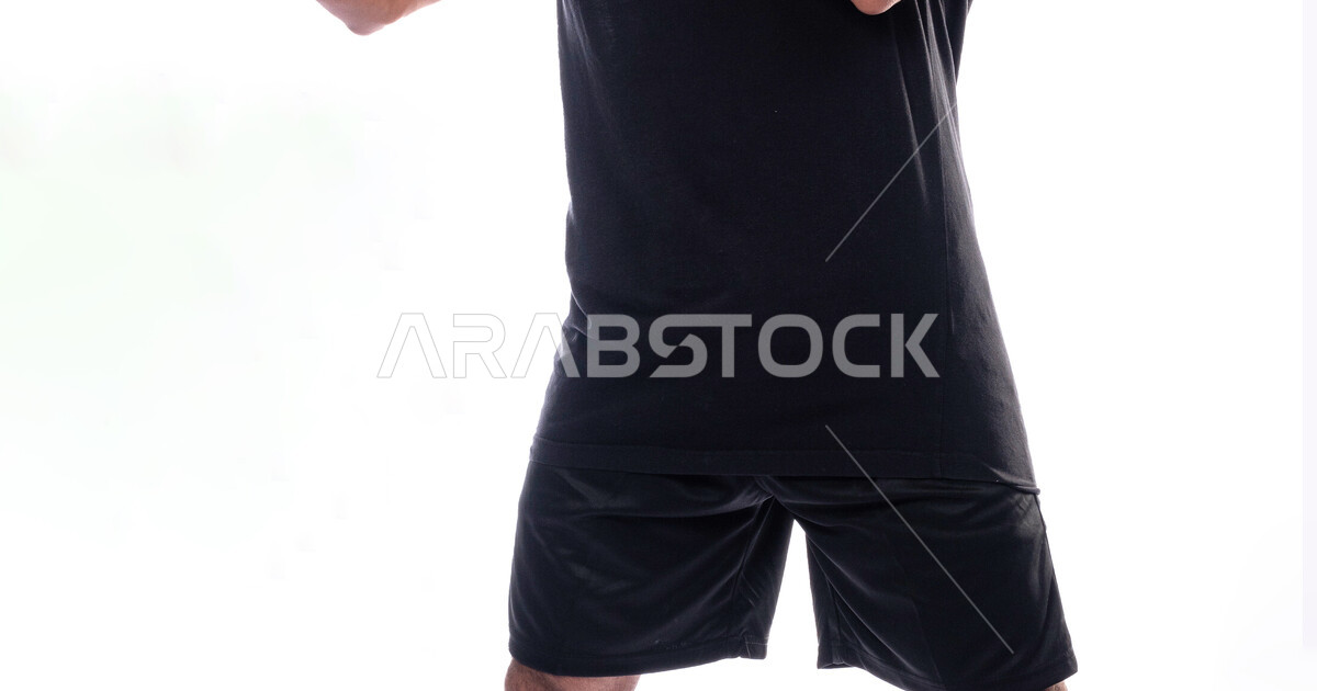 Portrait of a Saudi Arabian Gulf man wearing boxing gloves, practicing ...