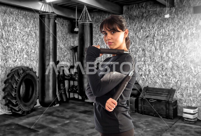 A Saudi Arabian Gulf girl in the gym, holding a Nunchaku (Bruce Lee ...