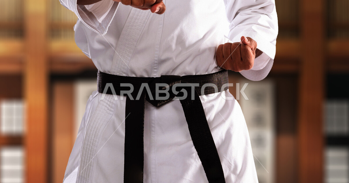 A young Arab Gulf, a Saudi Gulf, wearing a black belt karate costume ...