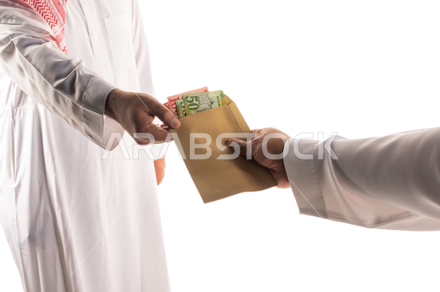Portrait of a Saudi Arabian Gulf man giving an envelope of paper money ...
