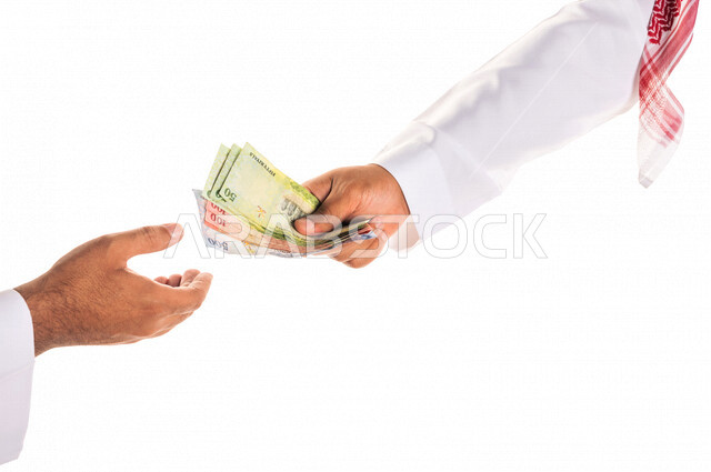 Portrait of a Saudi Arabian Gulf man giving paper money to a Gulf man ...