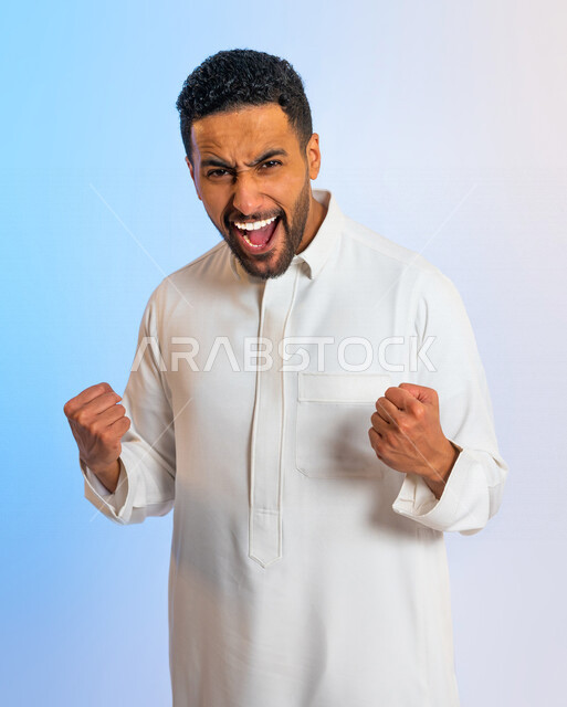 Portrait of a happy and smiling Saudi Arabian Gulf Arab man raising his ...