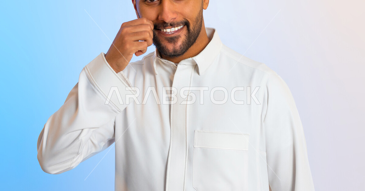 Portrait of a Saudi Arabian Gulf youth holding his mustache with ...