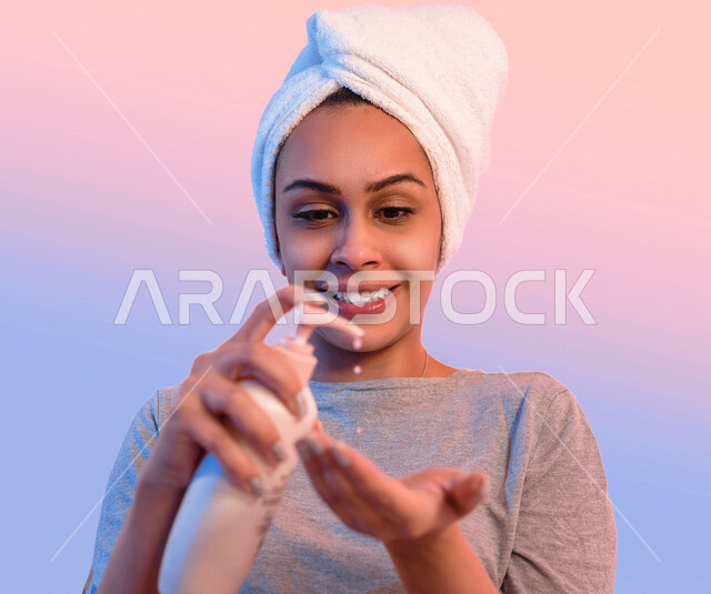 Portrait of a Saudi Arabian Gulf woman, putting a moisturizing cream on ...