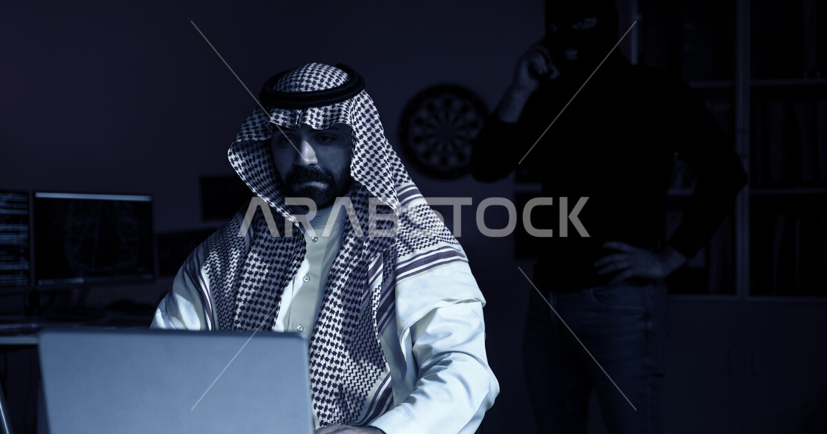 A Saudi Arabian Gulf businessman sitting in front of the laptop and ...