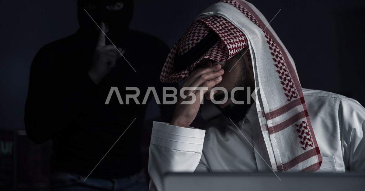 A Saudi Arabian Gulf man sitting in front of the laptop with gestures ...