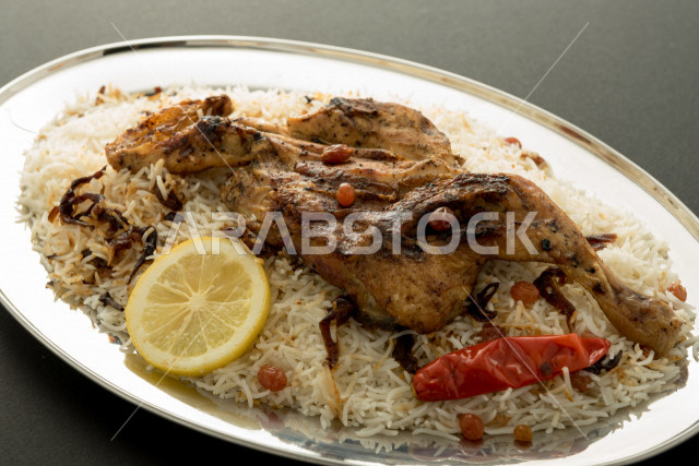 A plate of Bukhari rice with Madhbi chicken, traditional Saudi Arabian ...