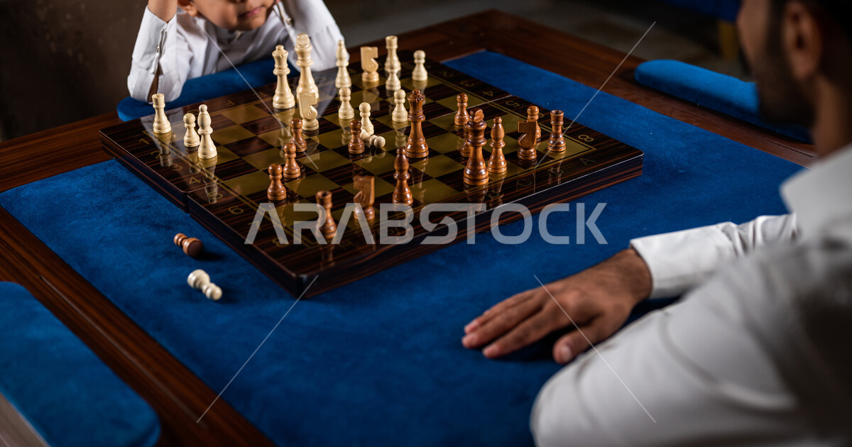 A close-up of a young Saudi Arabian Gulf young man and child playing ...