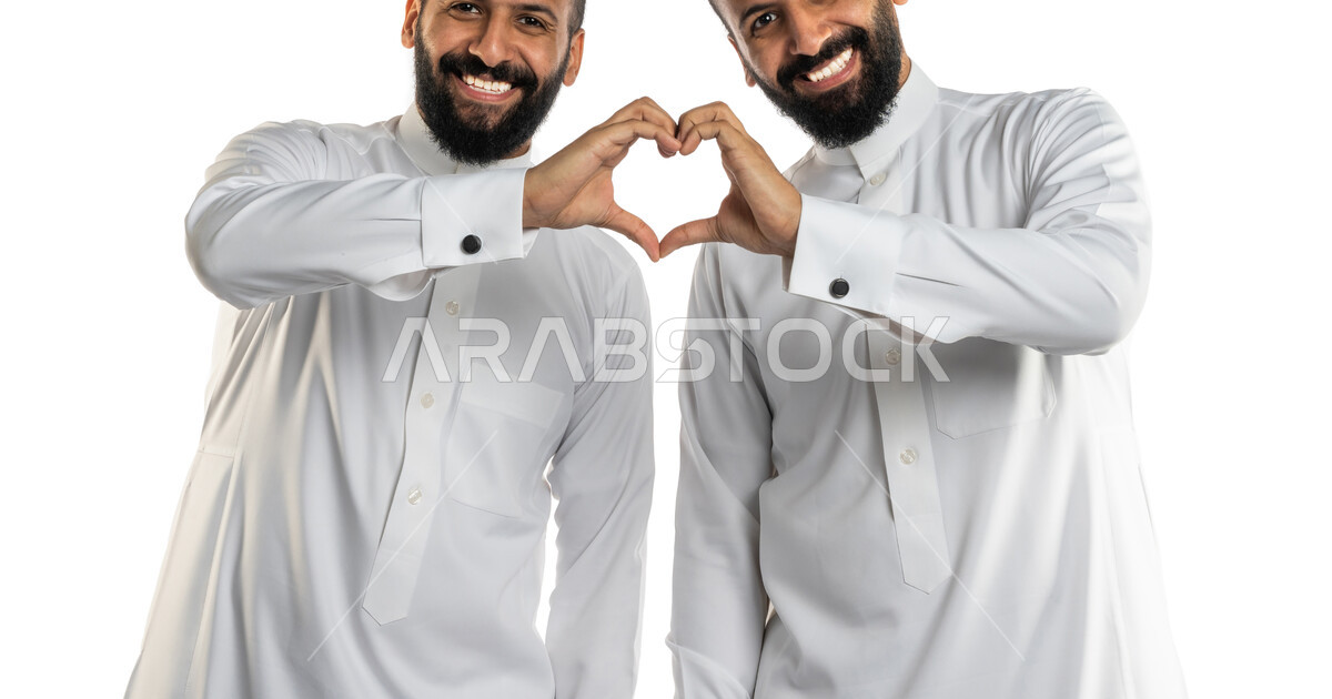 Portrait of two smiling and happy Saudi Arabian Gulf Arab twin men ...