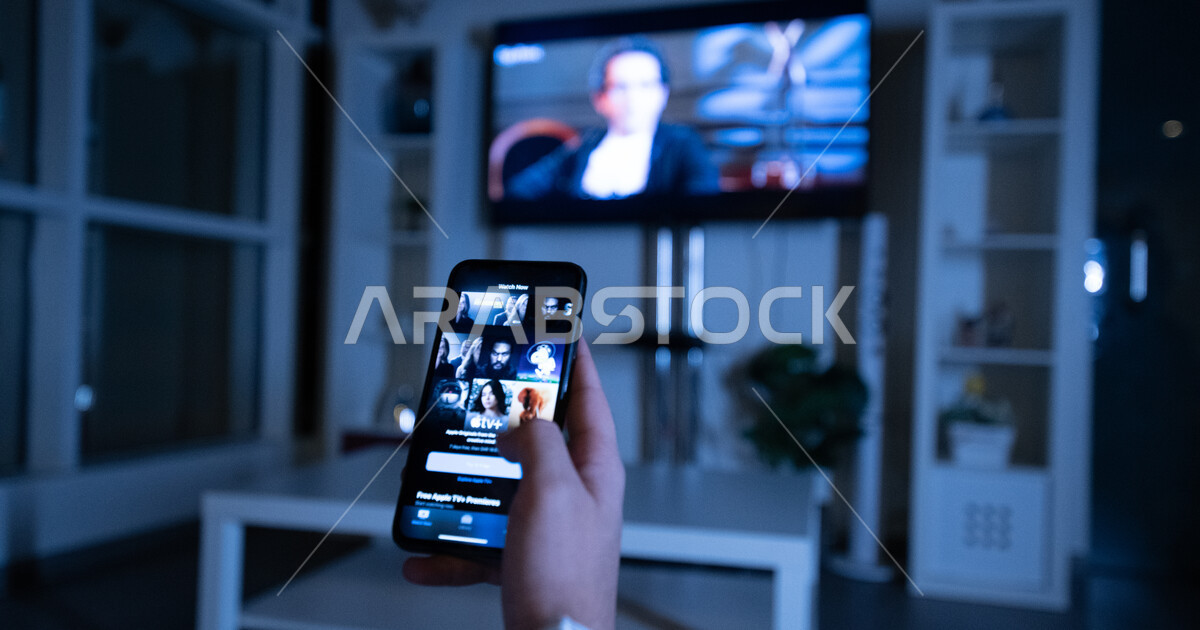 A young Saudi Arabian Gulf youth displays the mobile phone screen on ...