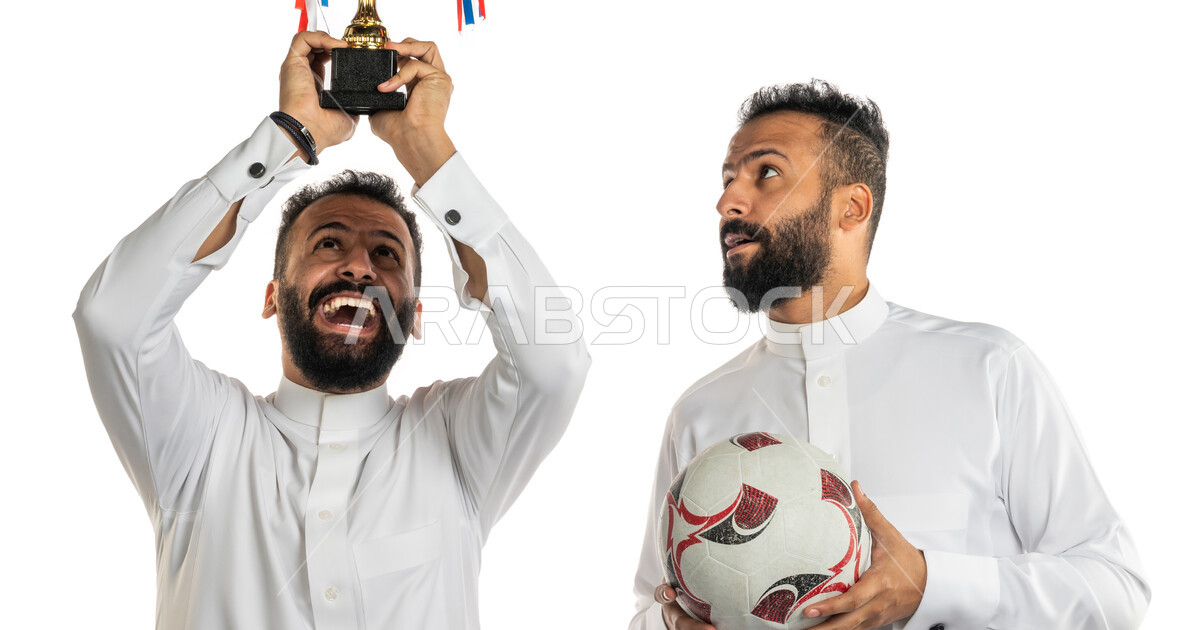 Portrait of two Saudi Arabian Gulf twin men, one of whom holds the ...