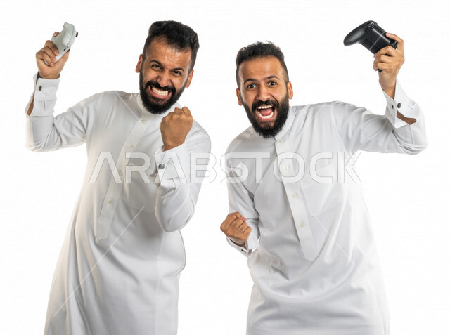 Portrait of two Saudi Arabian Gulf twin men holding a joystick with ...