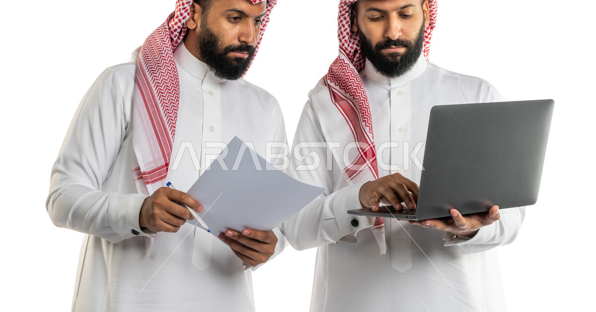 Portrait of two Saudi Arabian Gulf twin men discussing work tasks, co ...