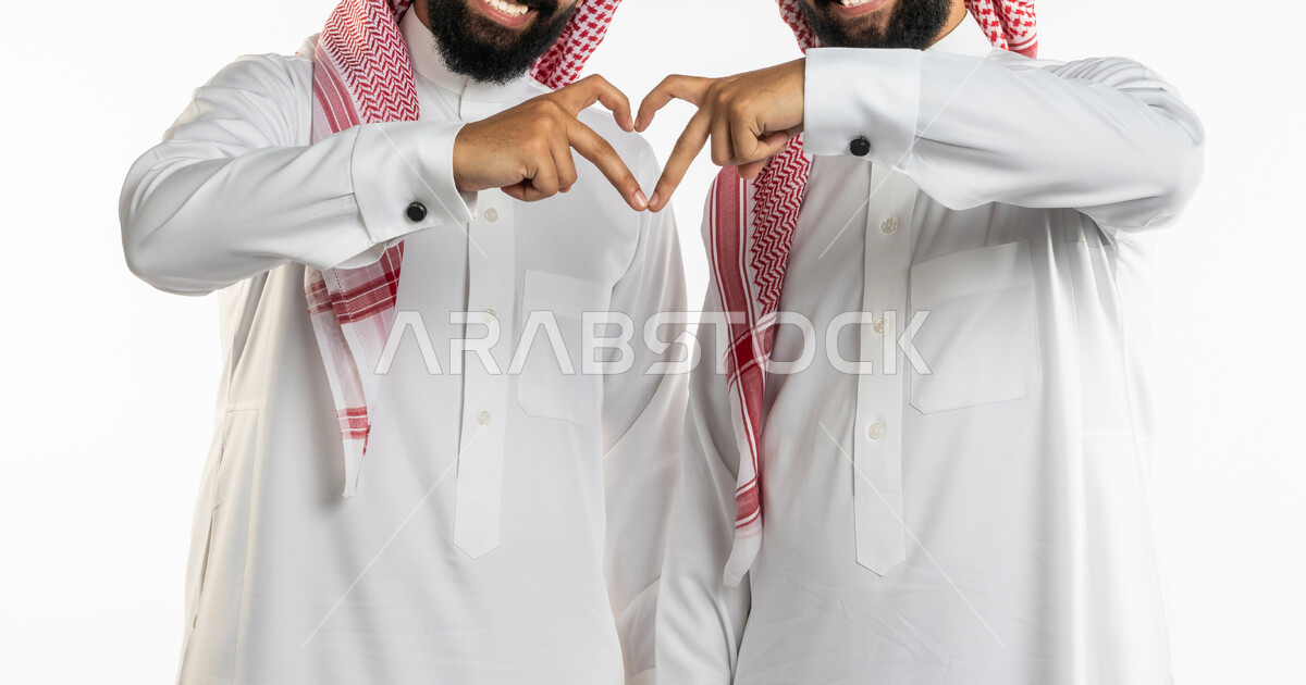Portrait of two smiling and happy Saudi Arabian Gulf Arab twin men ...