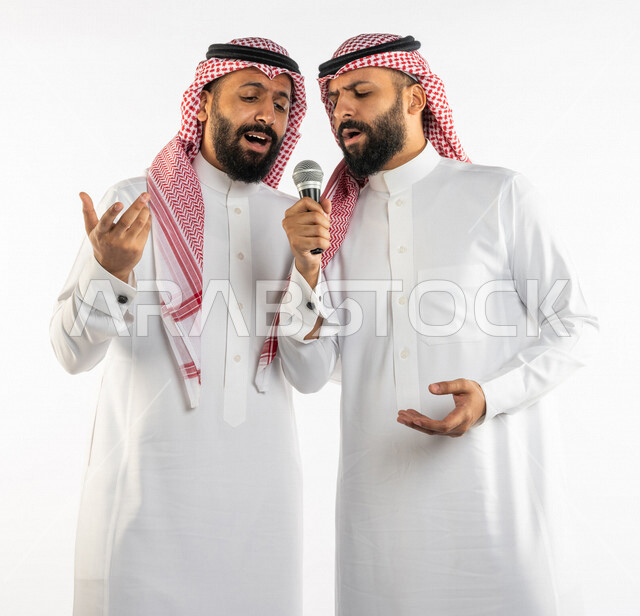 Portrait of two Saudi Arabian Gulf twin men enjoying singing, singing ...