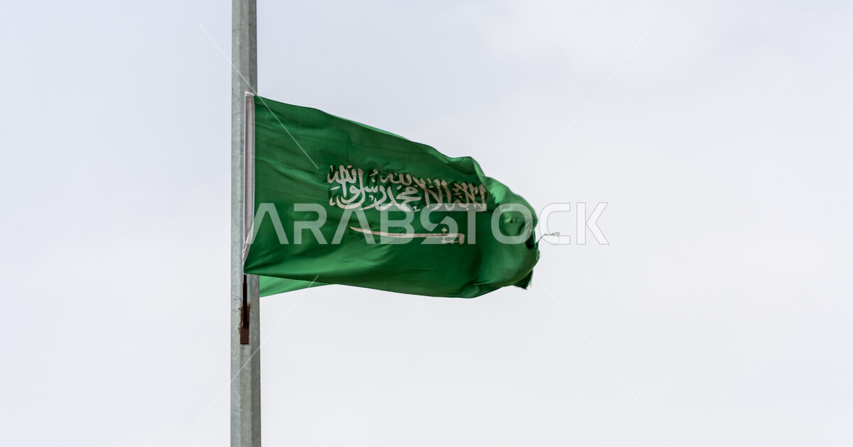 Close-up of the Saudi flag pole waving in the sky, the flag of Saudi ...