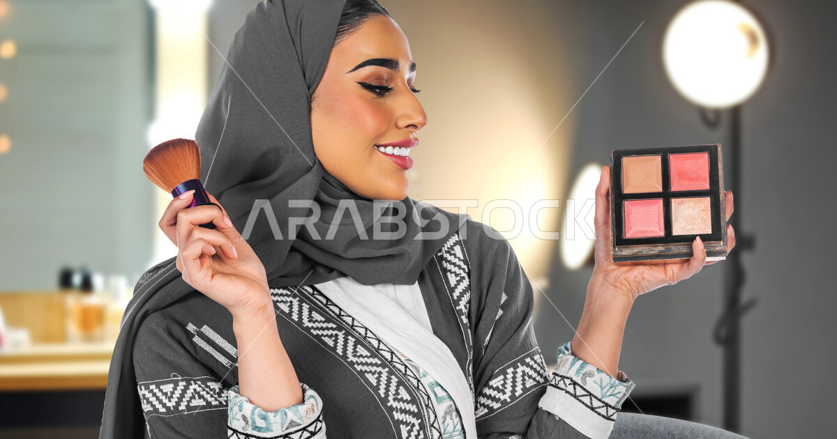 A Saudi Arabian Gulf woman carrying a facial skin cosmetics (brush), a ...