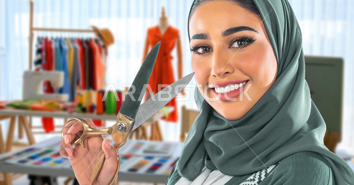 A smiling Saudi Arabian Gulf fashion designer holding scissors ...