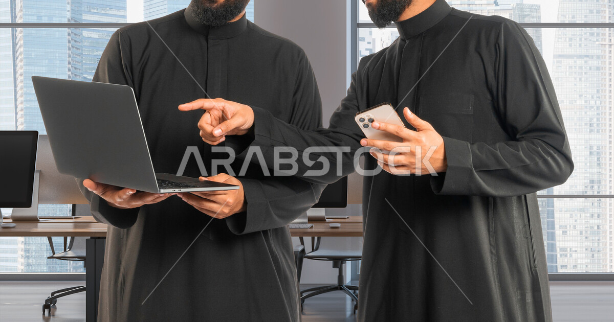 Two Saudi Arabian Gulf twin men, meeting co-workers at their workplace ...