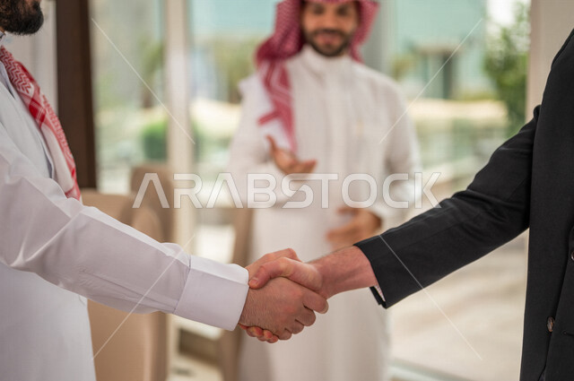 A Saudi Arabian Gulf businessman in the traditional Saudi dress shakes ...