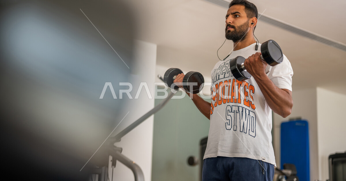 A Saudi Arabian Gulf man wears sports clothes and exercises using ...