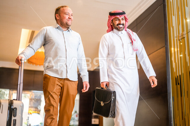 A Saudi Arabian Gulf man accompanied by an Arab tourist wearing casual ...