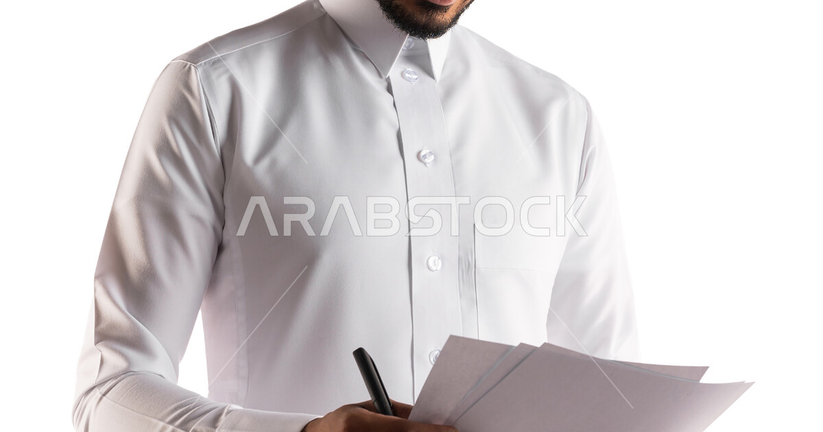 Portrait of a Saudi Arabian Gulf man holding a pen and a set of papers ...