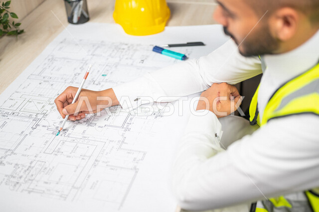 A Saudi Arabian Gulf engineer inside an engineering office, using ...