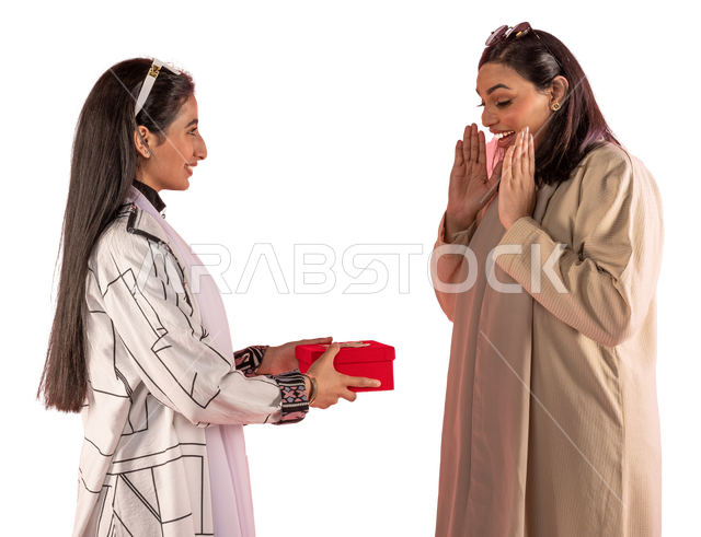 Portrait of a Saudi Arabian Gulf woman presenting a gift to her mother ...