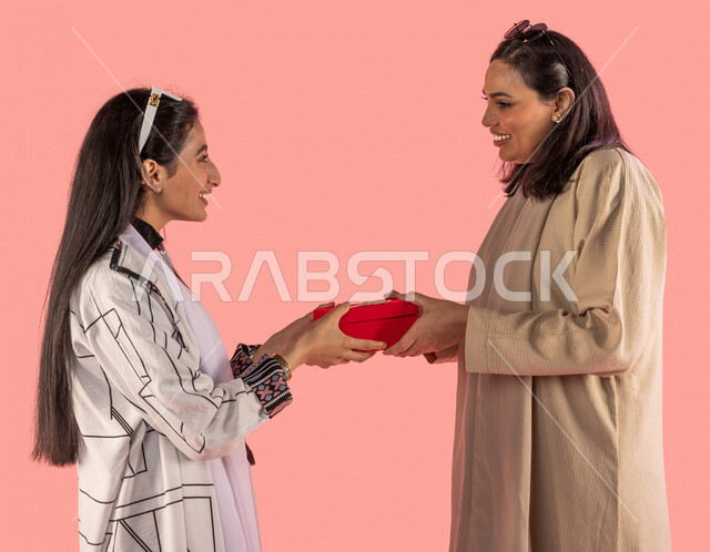A portrait of a Saudi Arabian Gulf woman who presents a gift to her ...
