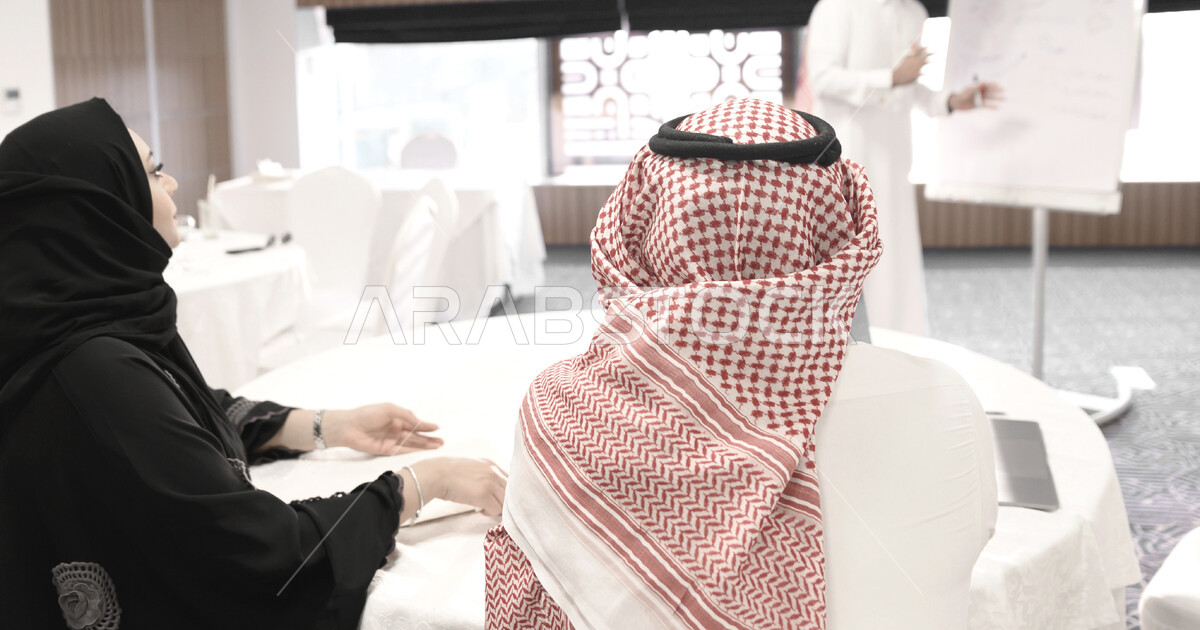 A Saudi Arabian trainer explains to Saudi Gulf trainees on a whiteboard ...