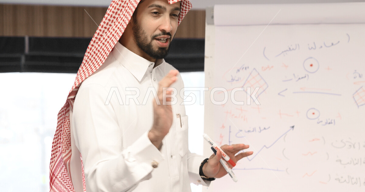 A Saudi Arabian trainer explaining on a white board, a Saudi ...