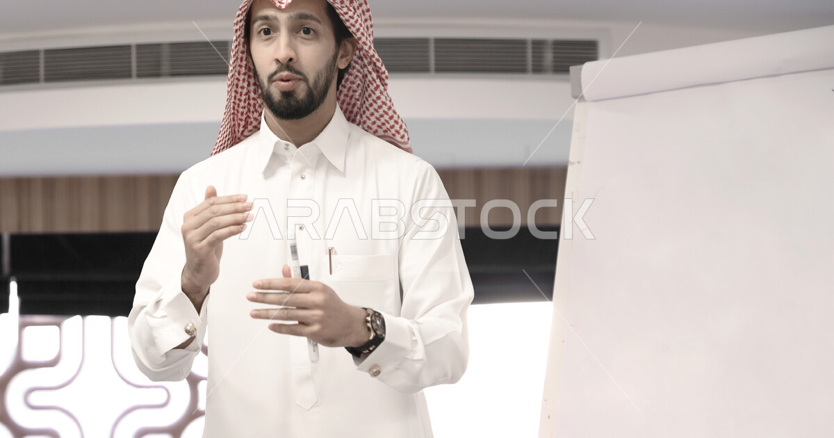 A Saudi Arabian trainer explaining on a white board, a Saudi ...