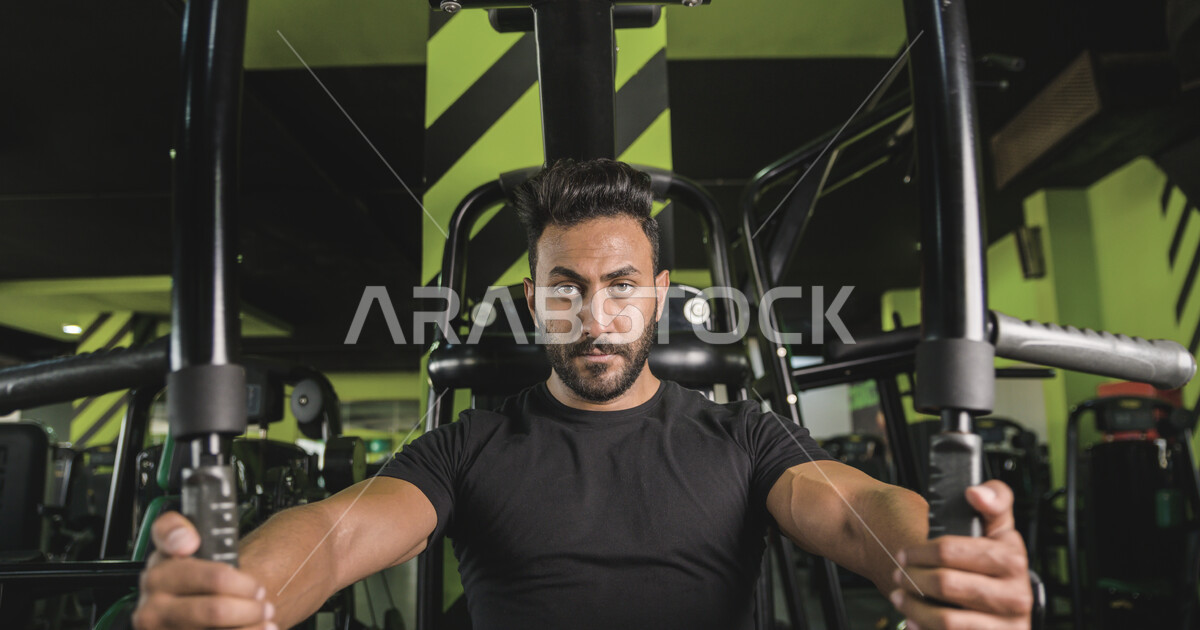 A young Saudi Arabian Gulf man exercising the chest muscle, a Saudi ...