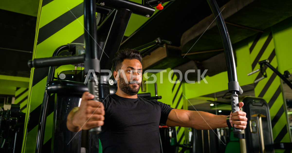 A young Saudi Arabian Gulf man exercising the chest muscle, a Saudi ...