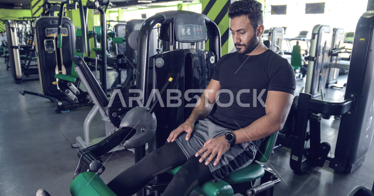 A young Saudi Arabian Gulf man is exercising on the thigh machine in ...