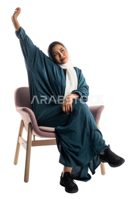 Portrait of a Saudi Arabian Gulf woman sitting on a chair and ...
